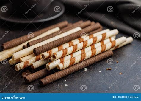 Assorted Chocolate And Vanilla Cream Filled Wafer Rolls On Dark Table