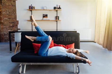 La Jeune Femme Superbe S Amusent La Maison Assis Sur Le Canap Dans Son Appartement Image