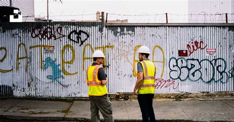 노란 재킷과 검은 바지를 입은 남자가 낮에 낙서가 있는 벽 옆에 서 있다 사진 Unsplash의 무료 뉴욕 이미지