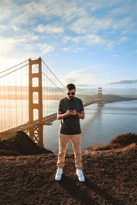 배경에 다리가 있는 절벽에 서 있는 남자 사진 Unsplash의 무료 배터리 스펜서 이미지