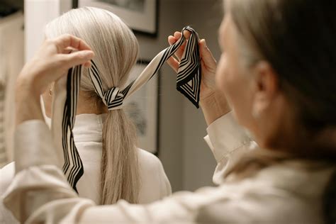 가정의 개별 스타일 개인 미용 거울 거울에 반사 낮 노인 돌보다 디테일 따뜻한 음색 라이프스타일 루틴 머리를 묶는 문화 반사 성숙한 여인 손