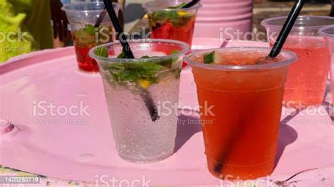 빨간색과 투명한 여름 칵테일 모히토 및 아페롤을 거리의 분홍색 주석 배럴에 플라스틱 컵에 넣습니다 피크닉 야외 파티의 시작 스프리츠에 대한 스톡 사진 및 기타 이미지