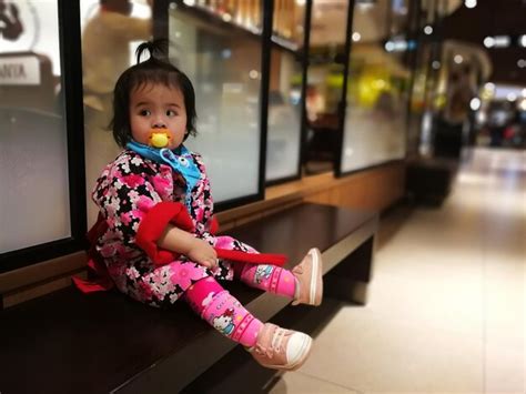 Premium Photo Cute Girl Sucking Pacifier While Sitting On Table In