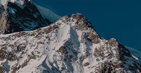 맑은 푸른 하늘 아래 눈 덮인 웅장한 산봉우리 · 무료 스톡 사진