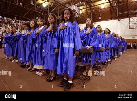 Multiethnic Middle School Girls Wearing Blue Graduation Gowns Recite