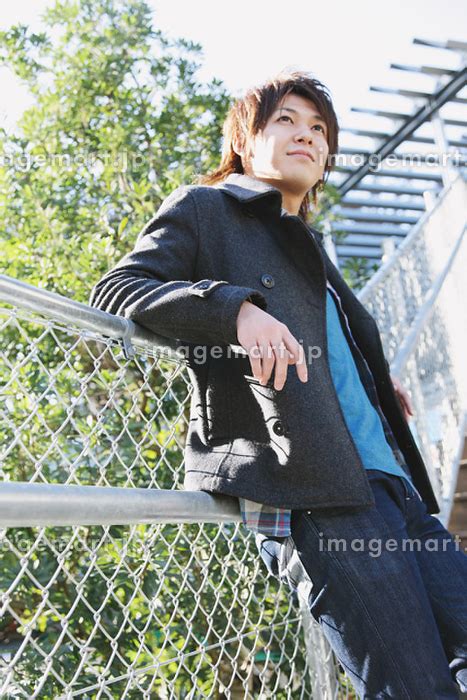 フェンスにもたれる日本人男性の写真素材 [129056533] イメージマート
