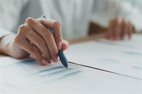 회사 사무실에서 컴퓨터 노트북으로 문서 보고서 쇼 차트와 그래프를 작성하는 전문 사업가 펜으로 가리키는 데이터 이익 서류 기획 마케팅 통계 분석 개념 가리키기에 대한 스톡