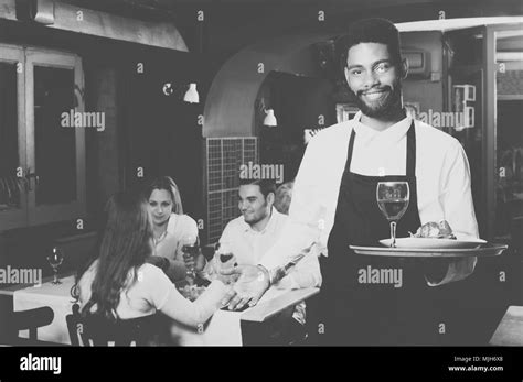 Portrait Of Adult People In Middle Class Restaurant And Positive Waiter