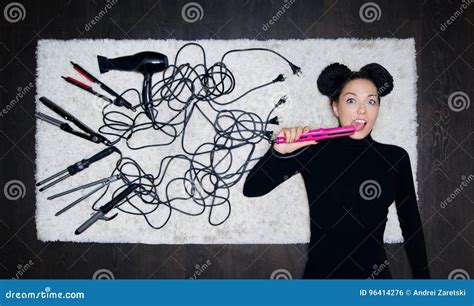 Young Charming Girl With Dreadlocks On Her Head Pressed Her Tong Stock