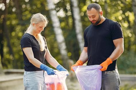 Free Photo Couple Collects Garbage In Garbage Bags In Park