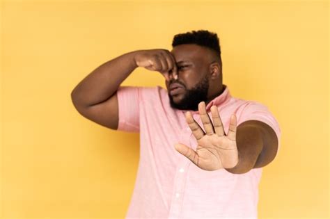 Premium Photo Man Pinching Nose Stop Breathing Disgusted By Smell Of Farting Expressing
