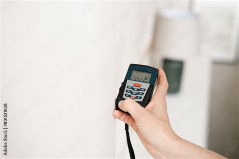 在装修期间，一名女子手持激光测距仪测量房间的长度和面积；图片 图片素材下载 卓特视觉 Adobe Stock 中国区官方合作伙伴