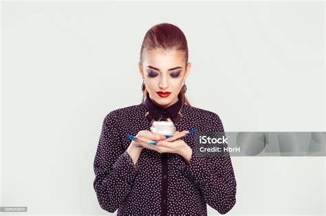 매직 미라클 크림 흰색에 분리 된 화장품 안티 에이징 페이스 로션 트리트먼트를 적용 한 아름다운 모델 클로즈업 여성 영양 수화 크림 병에 손 눈을 감고 아래를 내려다 보고