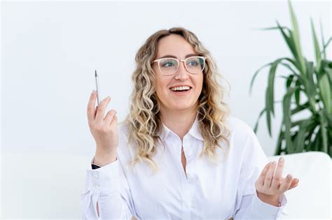 금발과 곱슬 머리를 가진 행복한 젊은 여성의 비즈니스 초상화 미니멀 한 사무실의 배경에 대해 화상 통화 25 29세에 대한 스톡 사진 및 기타 이미지 Istock