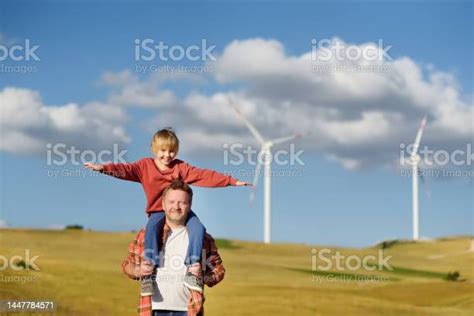 재생 가능한 전기 에너지 생산을 위한 발전소의 배경에 있는 환경 운동가 남자와 아이 사람과 풍차 발전 전기용 풍력 터빈 그린 에너지 2명에 대한 스톡 사진 및 기타 이미지