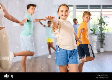 Smiling Tween Girl Practicing Vigorous Dance In Pair With Boy Stock