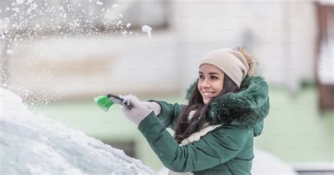 겨울 옷을 입은 젊은 여성은 겨울에 아파트 블록 밖에서 눈에서 차를 청소합니다 사진 Unsplash의 얼음 이미지