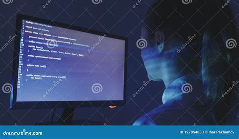 Portrait Of Young Woman Hacker Programmer Working At A Computer At