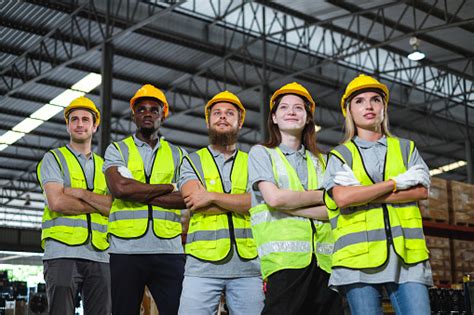 여성과 남성 산업 엔지니어 팀이 팔짱을 끼고 서서 공장을 열심히 바라 보았습니다 25 29세에 대한 스톡 사진 및 기타 이미지 25 29세 30 34세 경영자