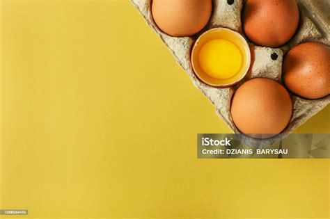 신선한 갈색 계란과 노른자가 있는 깨진 달걀은 밝은 노란색 배경에 재활용 된 종이 에코 트레이에 텍스트 복사 공간을 위한 공간이 있습니다 0명에 대한 스톡 사진 및 기타
