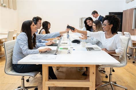 사무실에서 일 하는 사업가 들과 핸드폰을 지나가는 여성들 건네주기에 대한 스톡 사진 및 기타 이미지 건네주기 비즈니스 휴대전화 Istock