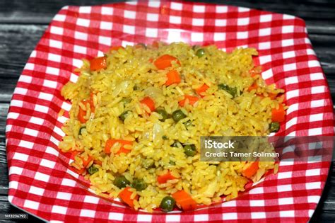 얇게 썬 양파를 곁들인 야채 완두콩과 당근을 곁들인 뜨거운 찐 긴 곡물 노란색 바스마티 쌀 한 접시 중국 요리 조리법 및 동양 아랍어와 중국 기원 건강한 생활방식에 대한