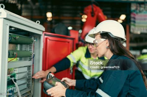 산업 공장에서 자동 로봇 기계를 점검 및 수리하는 로봇 컨트롤러를 들고 있는 전문 엔지니어 제조 생산을 위해 로봇 팔 시스템으로