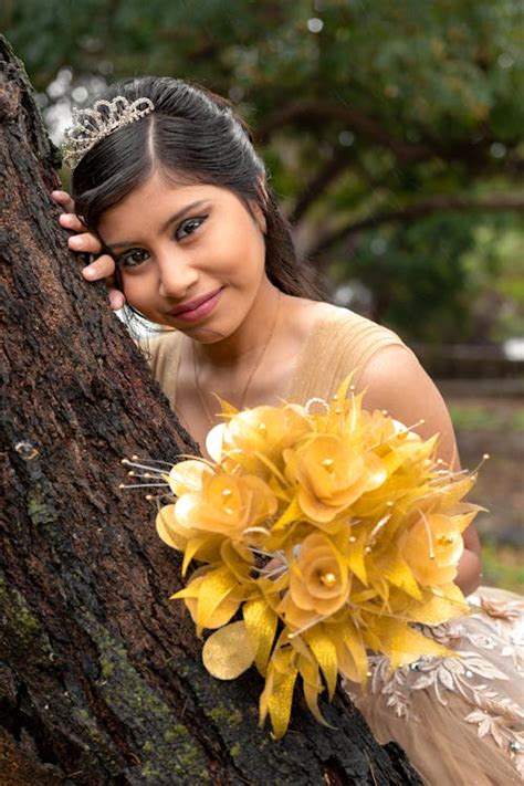 꽃 나무 모델 미소 짓는 부케 빨간 드레스 서 있는 수직 쐈어 여성 왕관 잡고 있는 초상화 패션 사진에 관한 무료 스톡 사진