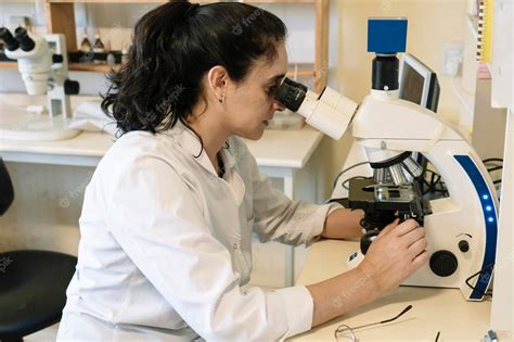 Premium Photo Female Lab Technician Analyzing Sample Through Microscope