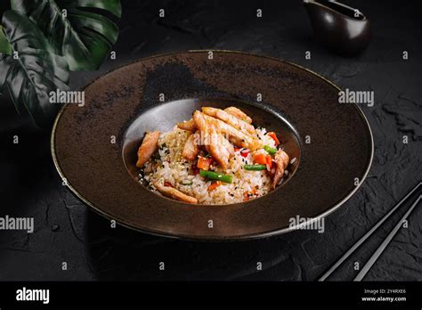 Savory Chicken Fried Rice Served On A Stylish Dark Plate Perfect For A