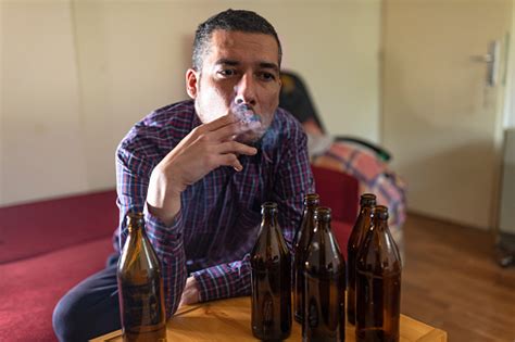 젊은 슬픈 술에 취한 남자는 맥주와 알코올을 마시는 낭비 고통과 정서적 스트레스에 외롭고 필사적 사람과 알코올 남용 중독과 남자 우울증 개념 가정 생활에 대한 스톡 사진 및