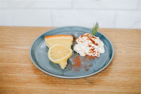 휘핑 크림을 곁들인 레몬 타르트 흰 접시에 슬라이스 맛있고 식욕을 돋우며 수제 디저트 전통적인 프렌치 스위트 페이스트리 타르트 감귤류 과일에 대한 스톡 사진 및 기타 이미지