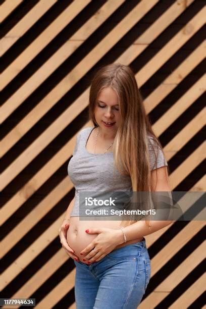 수직 사진 줄무늬 배경에 젊은 아름답고 행복한 임신 소녀 두 번째 삼분기는 그의 뱃속에 손을 잡고 가족에 대한 스톡 사진 및 기타 이미지 Istock