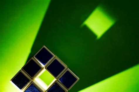 Premium Photo Cube Casting Shadow On Green Surface