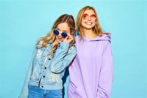 유행 여름 옷을 입고 두 젊은 아름 다운 금발 웃는 Hipster 여자 선글라스에 파란색 벽 근처 포즈 섹시 평온한 여자 미쳐 가고 포옹하는 긍정적 인 모델 무료 사진
