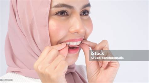 흰색 배경 스튜디오 치과 의료 및 치열 교정 개념을 통해 치아에 대한 다채로운 보유자를 들고 젊은 무슬림 여성 개선에 대한 스톡 사진 및 기타 이미지 Istock