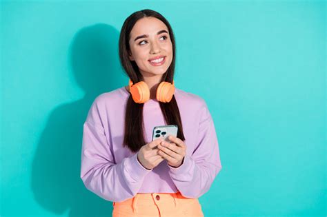 아름 다운 아가씨 모습 빈 공간 홀드 장치 헤드폰 옷 세련된 보라색 의류 아쿠아 마린 색상 배경에 고립 된 사진 Brand Name Smart Phone에 대한 스톡 사진