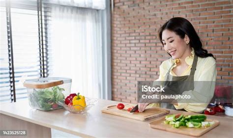 부엌 집에서 야채 샐러드 찹을 요리하는 아시아 요리사 소녀의 초상화 가정 생활 방식에서의 새로운 정상적인 작업 건강 식품 환경 친화적 인 수제 식사 행복 스스로 아시아 주부