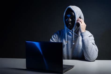 Premium Photo Anonymous Hacker In Mask Programmer Uses A Laptop And