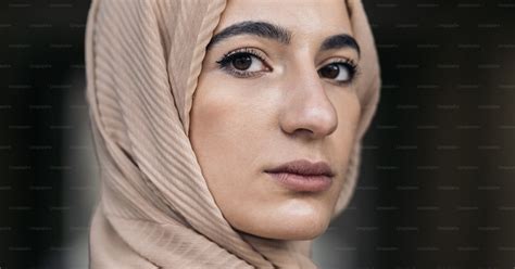 히잡을 쓴 아름다운 젊은 무슬림 여성이 야외에서 카메라를 보고 있다 사진 Unsplash의 히잡 이미지