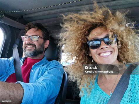 여행 휴가 커플은 차 안에서 즐거운 시간을 보내고 셀카 사진을 찍는다 남자 운전자와 여자 승객은 차량에서 재미있는 여가 활동을 하고 있다 안전벨트를 착용하고 있는 사람들