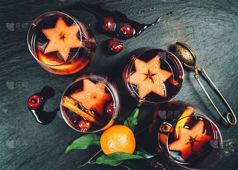 静物俯视图与热热葡萄酒和香料水果肉桂在薄玻璃杯上黑色纹理的石头桌子圣诞节和新年庆祝概念形象