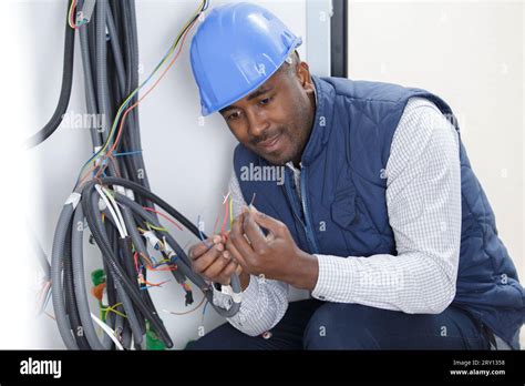 Electrician Checking The Voltage Level In Wall Socket Cables Stock Photo Alamy