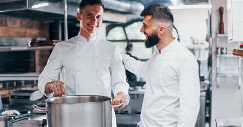 다른 직원의 도움으로 부엌에서 음식을 요리하는 흰색 유니폼을 입은 요리사 직장에서 바쁜 하루 사진 Unsplash의 요리사 이미지