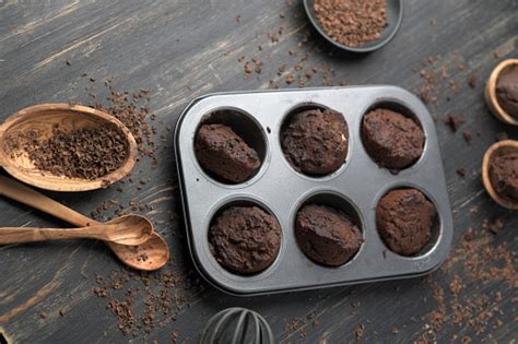 초콜릿 토 핑 Delish와 간단한 디저트와 수 제 초콜릿 머핀 초콜릿 드랍 스와 맛 있는 수 제 머핀 측면에 어두운 배경