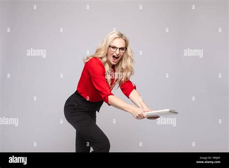 Side View Of Angry Female Manager Crashing Computer And Shouting On White Isolated Background In