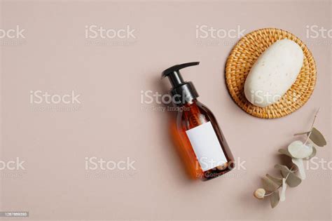 갈색 배경에 호박색 샴푸 디스펜서 병 모형 유기농 비누 및 유칼립투스 잎 Spa 욕실 화장품 세트 보습제에 대한 스톡 사진 및