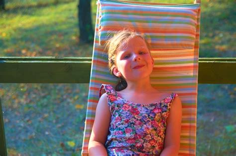 어린 소녀는 베란다에 정원 해먹이에 앉아 있다 작은 소녀는 정원에는 일광욕이 하고있다 꿈꾸는 듯한 낭만적인 이미지입니다 여름 행복 한 유년 시절 개념 귀여운에 대한 스톡