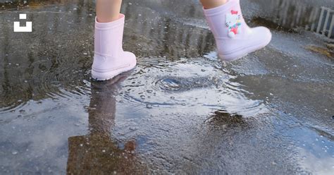 흰색과 분홍색 물방울 무늬 드레스와 젖은 땅에 서 있는 흰색 부츠를 입은 소녀 사진 Unsplash의 무료 웅덩이 이미지