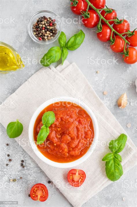 향신료와 재료가 있는 콘크리트 배경에 그릇에 담긴 전통적인 이탈리아 마리나라 소스 맨 위 보기입니다 공간을 복사합니다 0명에